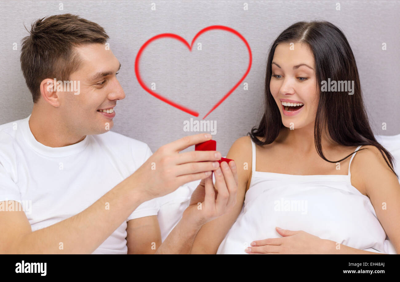 man giving woman little red box and ring in it Stock Photo - Alamy