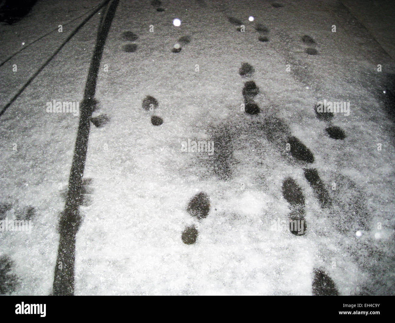 Shoes footprints in the snow on the pavement at night Stock Photo - Alamy