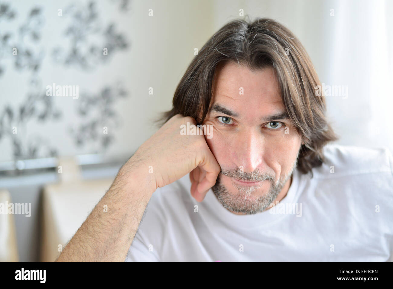 Portrait of man sitting in living room Stock Photo - Alamy