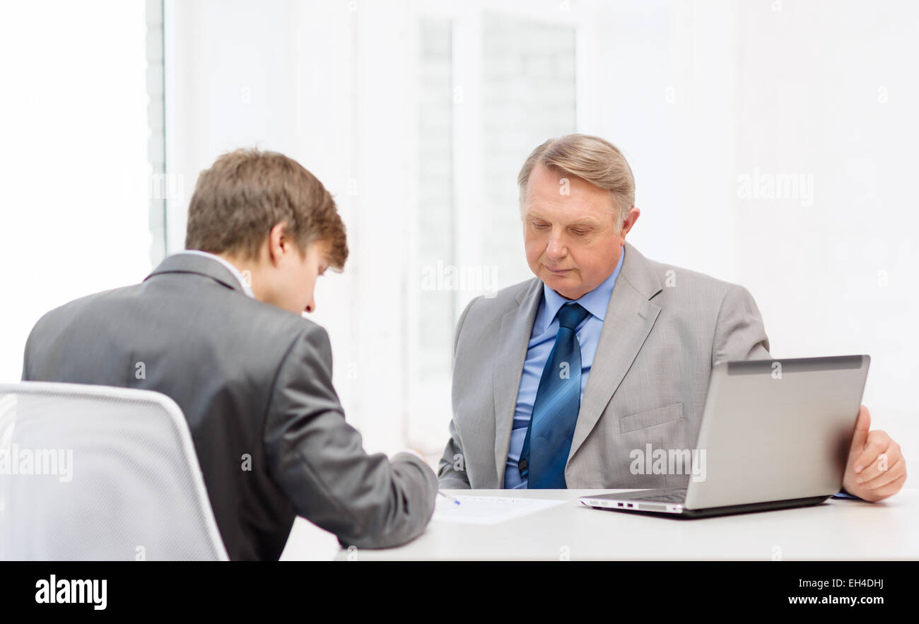 older man and young man signing papers in office Stock Photo - Alamy