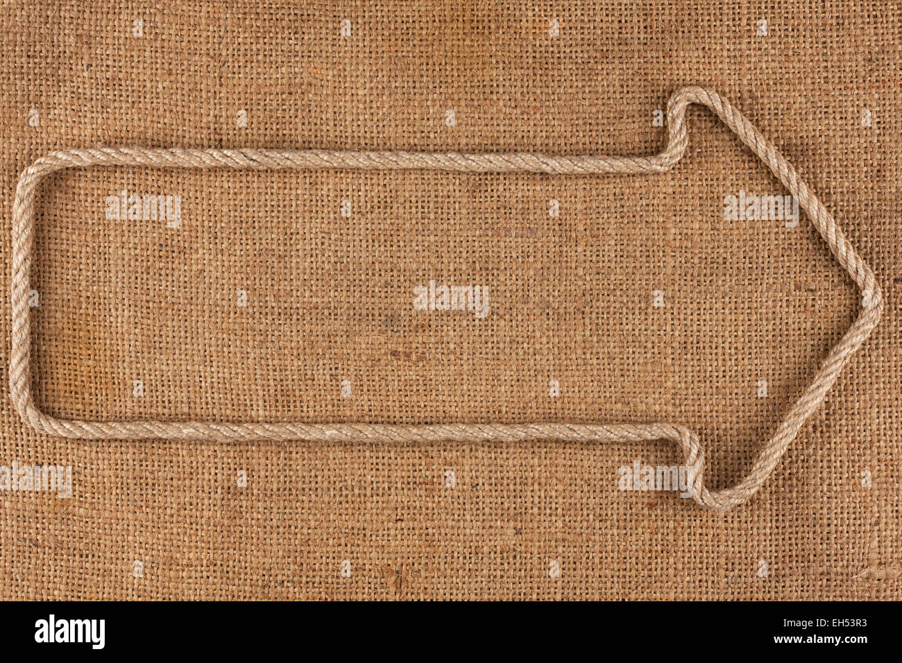 Arrow made of rope lying on burlap, as background, texture Stock Photo ...