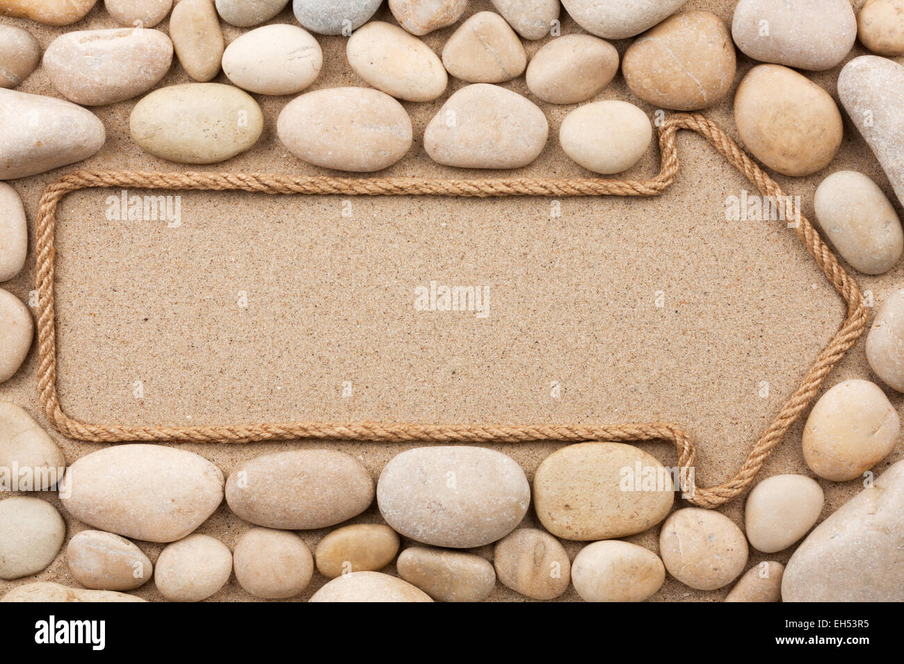 Pointer made of rope with white stones, lying on the sand Stock Photo ...
