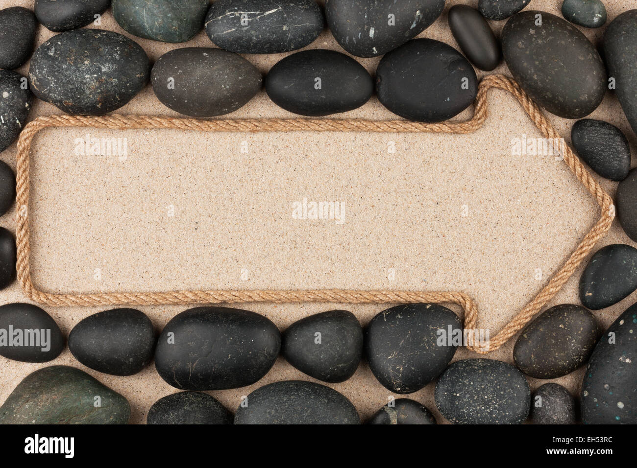 Pointer made of rope with black stones, lying on the sand Stock Photo ...