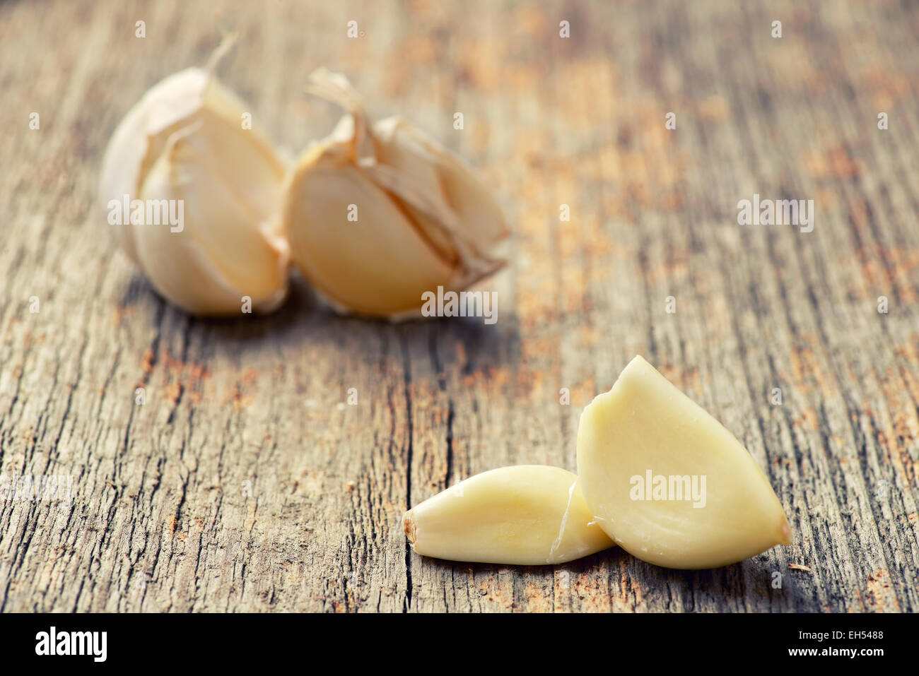 Garlic set on a wooden texture in natural light Stock Photo - Alamy