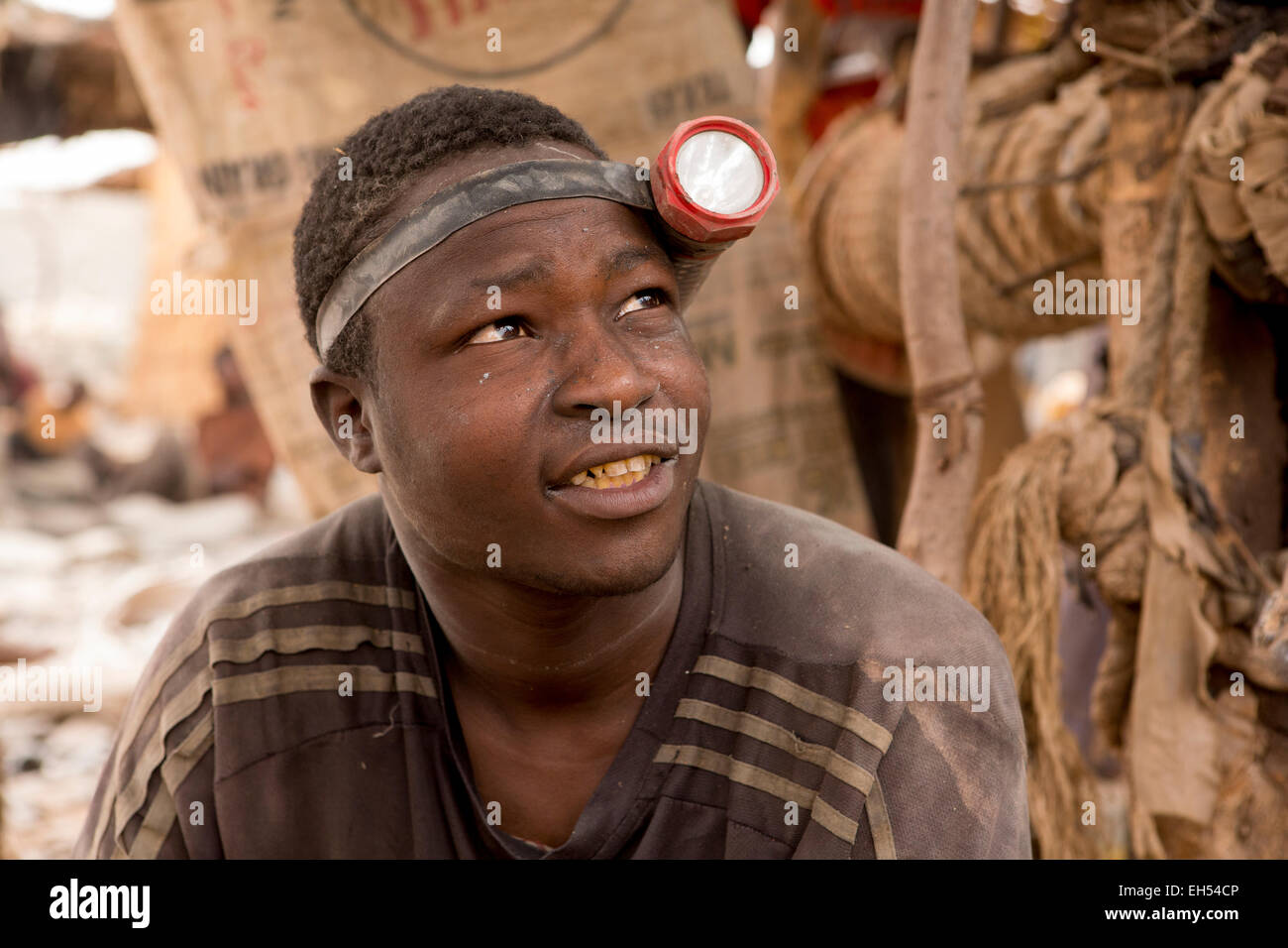 KOMOBANGAU, NIGER, : A miner wearing his head torch beside the vertical ...