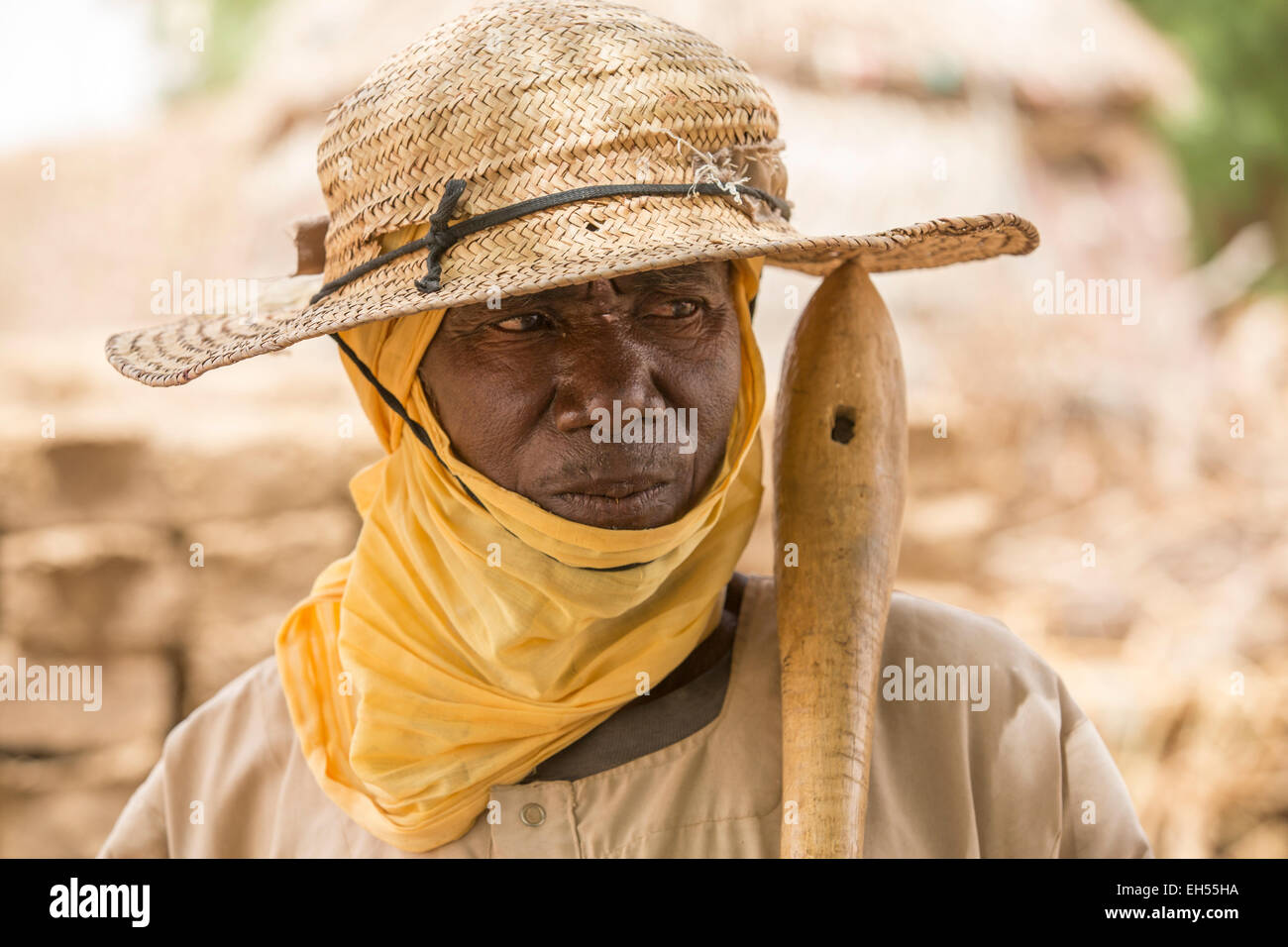 Tera, west Niger: A farmar carries his axe and wears his hat against ...