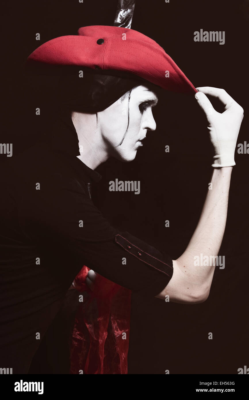 Mime in a red cowboy hat on a black background Stock Photo - Alamy