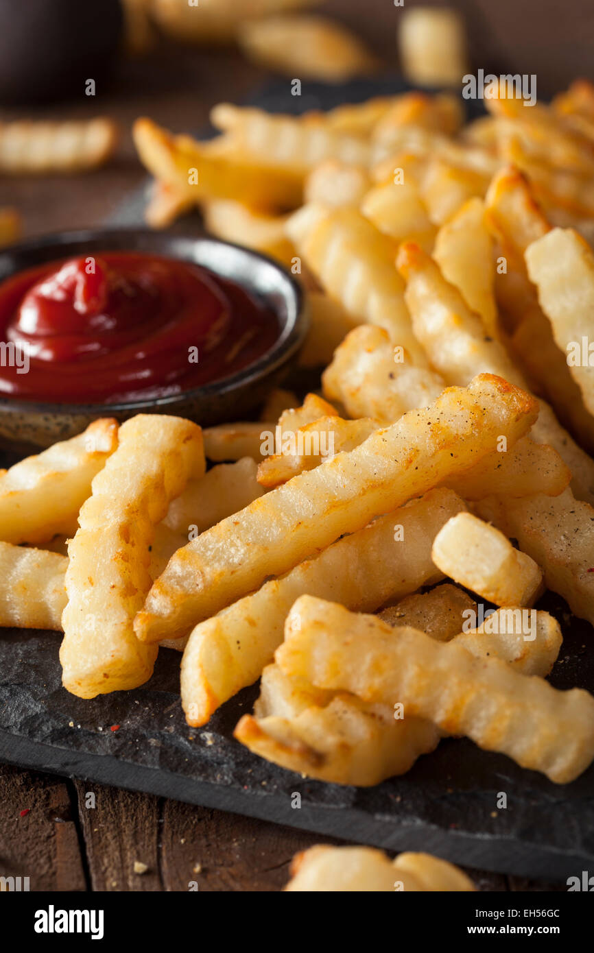 Unhealthy Baked Crinkle French Fries with Ketchup Stock Photo - Alamy