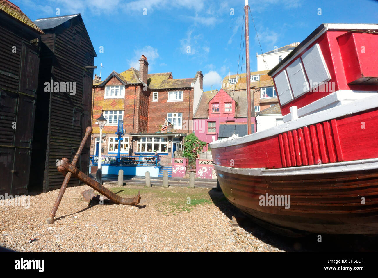 Fishing boat and traditional net huts, anchor and the Dolphin pub ...
