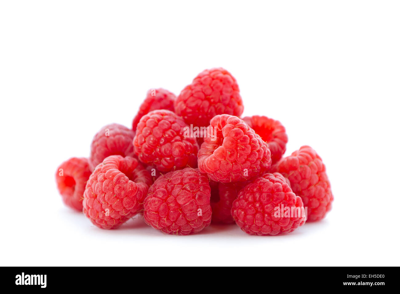 Side view of a pile of fresh organic raspberries on white background ...