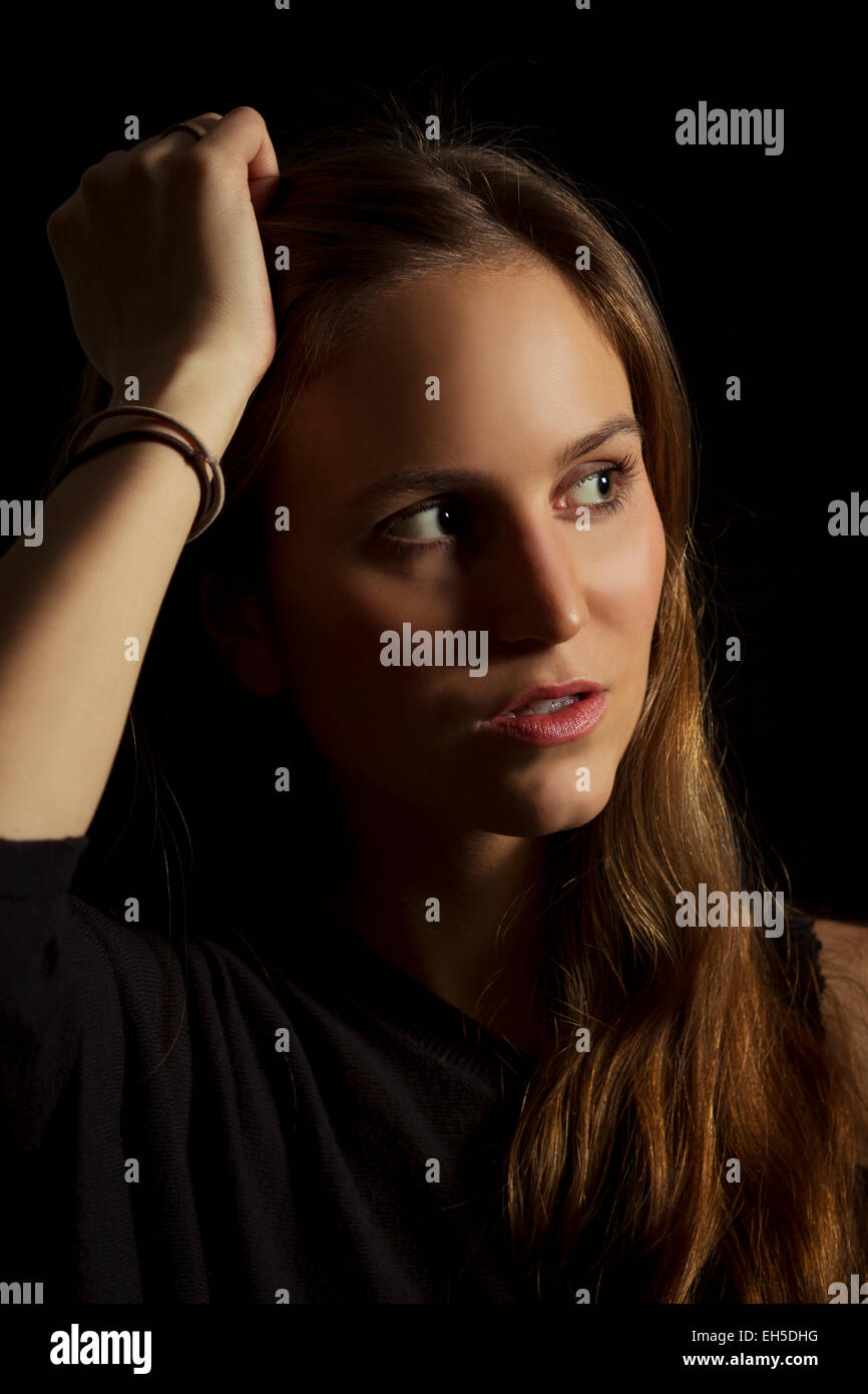 Studio shot of a young woman / girl with lowkey lighting. Black ...