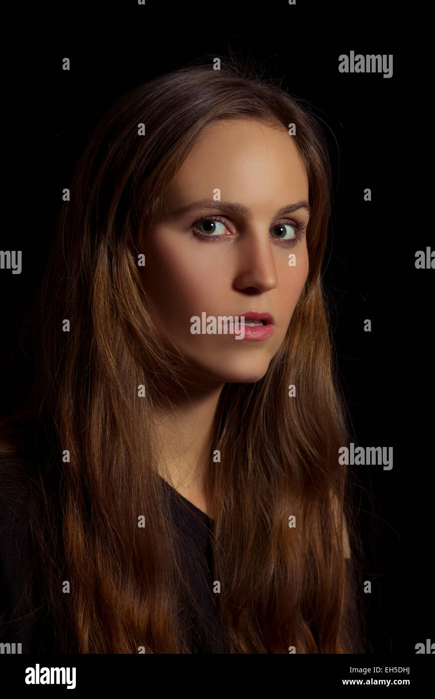 Studio shot of a young woman / girl with lowkey lighting. Black ...