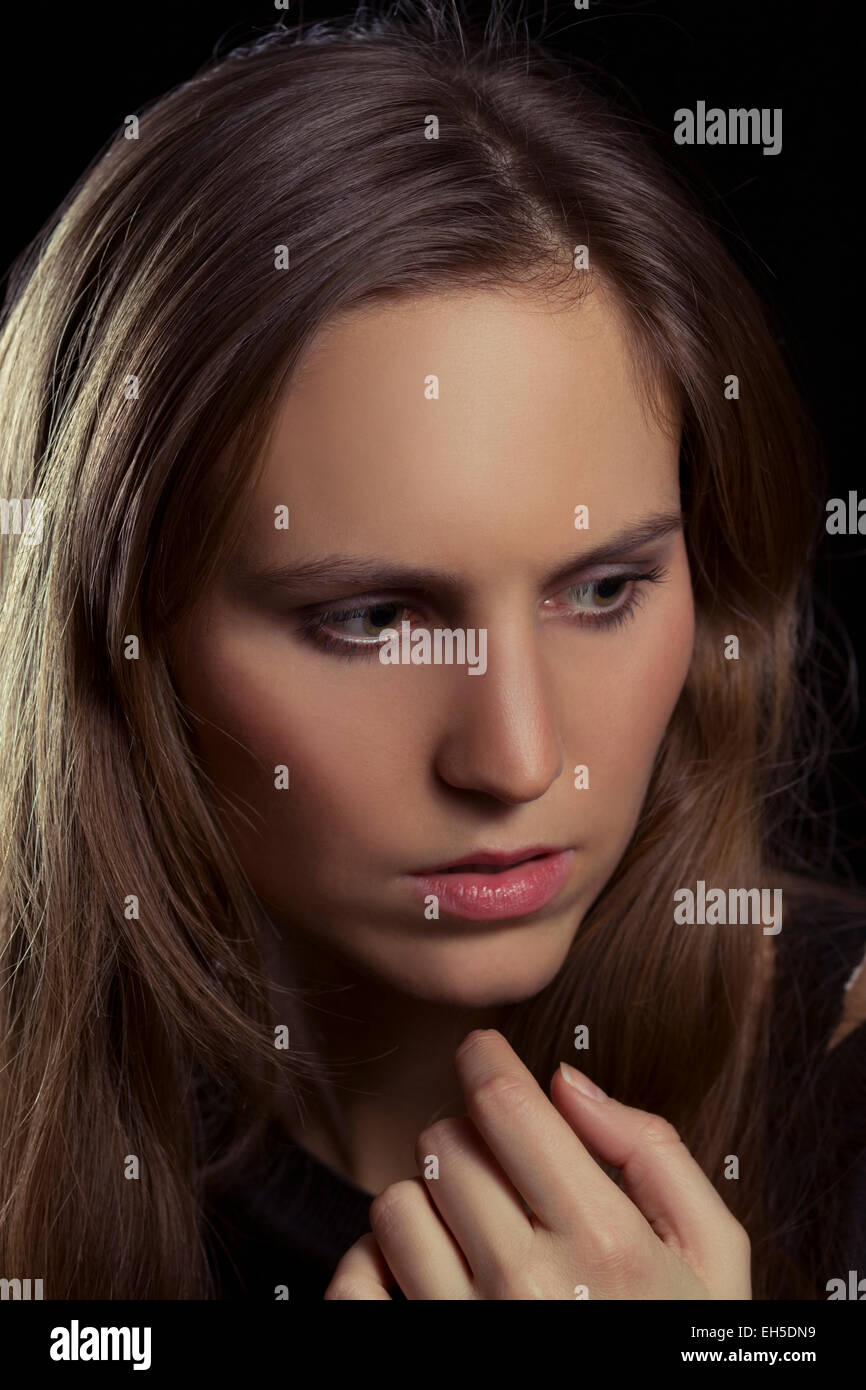 Studio shot of a young woman / girl with lowkey lighting. Black ...