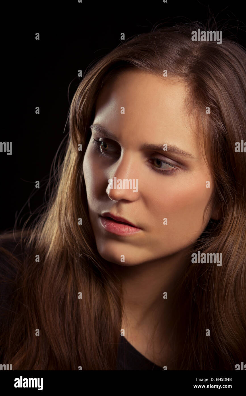 Studio shot of a young woman / girl with lowkey lighting. Black ...