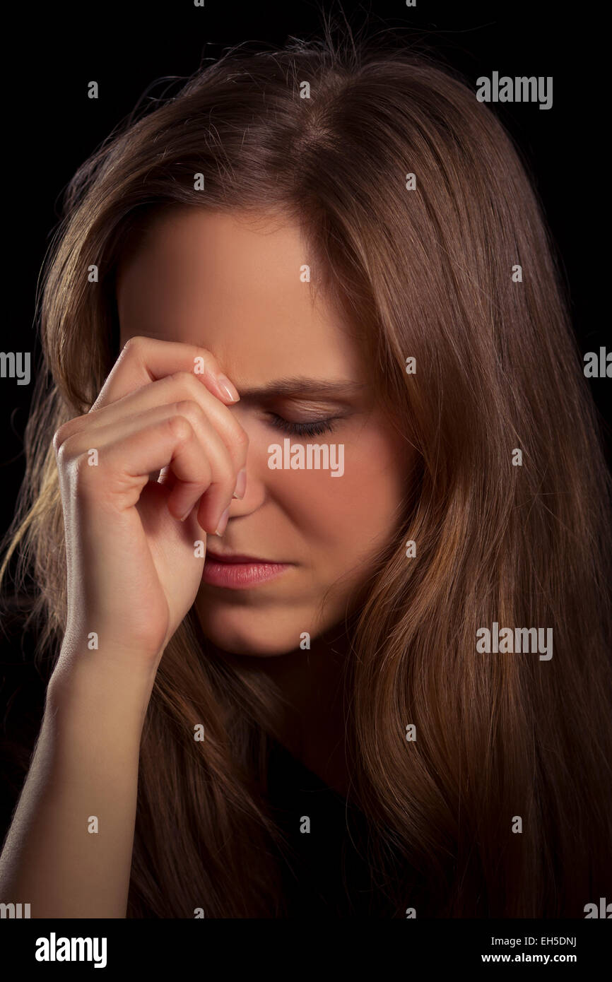 Studio shot of a young woman / girl with migraine / headache / anger ...