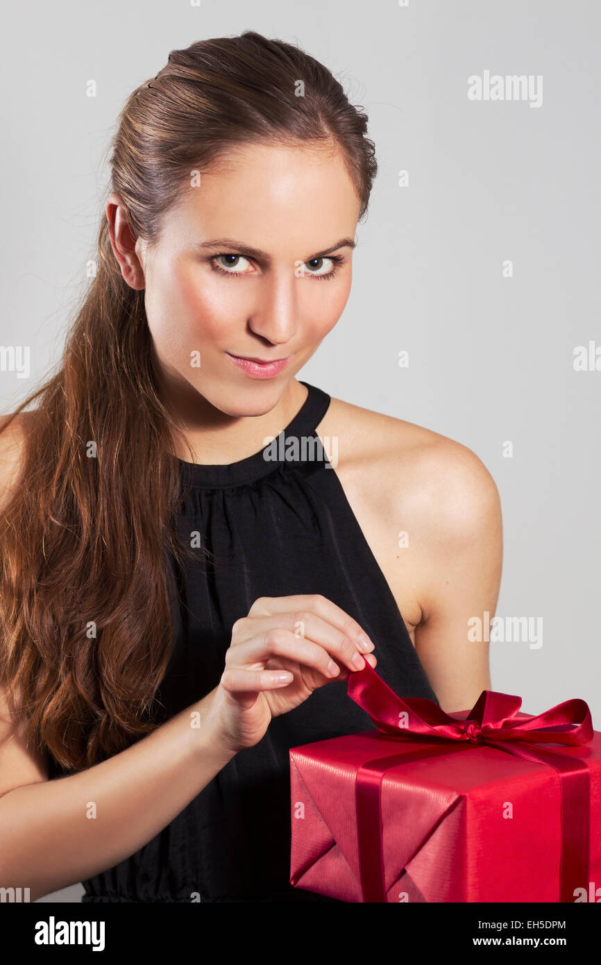 Excited young attractive woman open christmas gift or birthday present ...