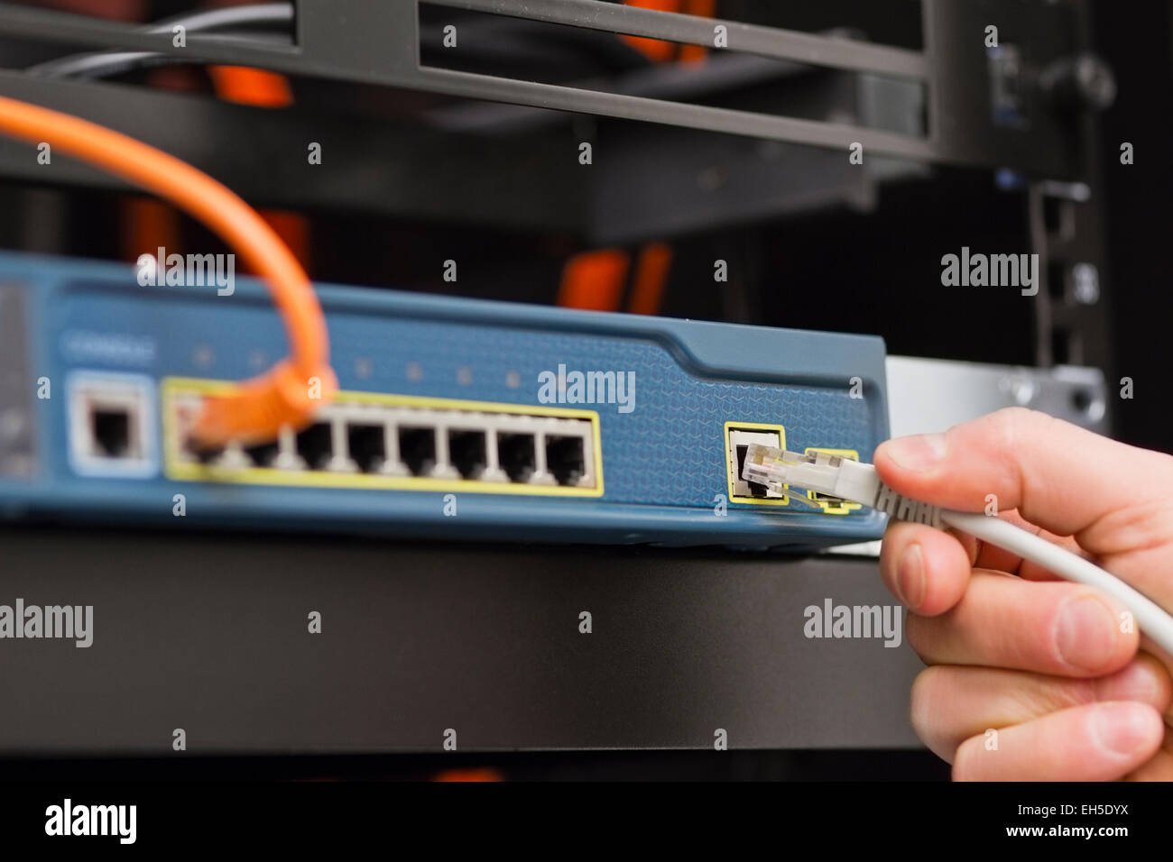 Close up of a IT consultant inserting / connecting a network cable into ...