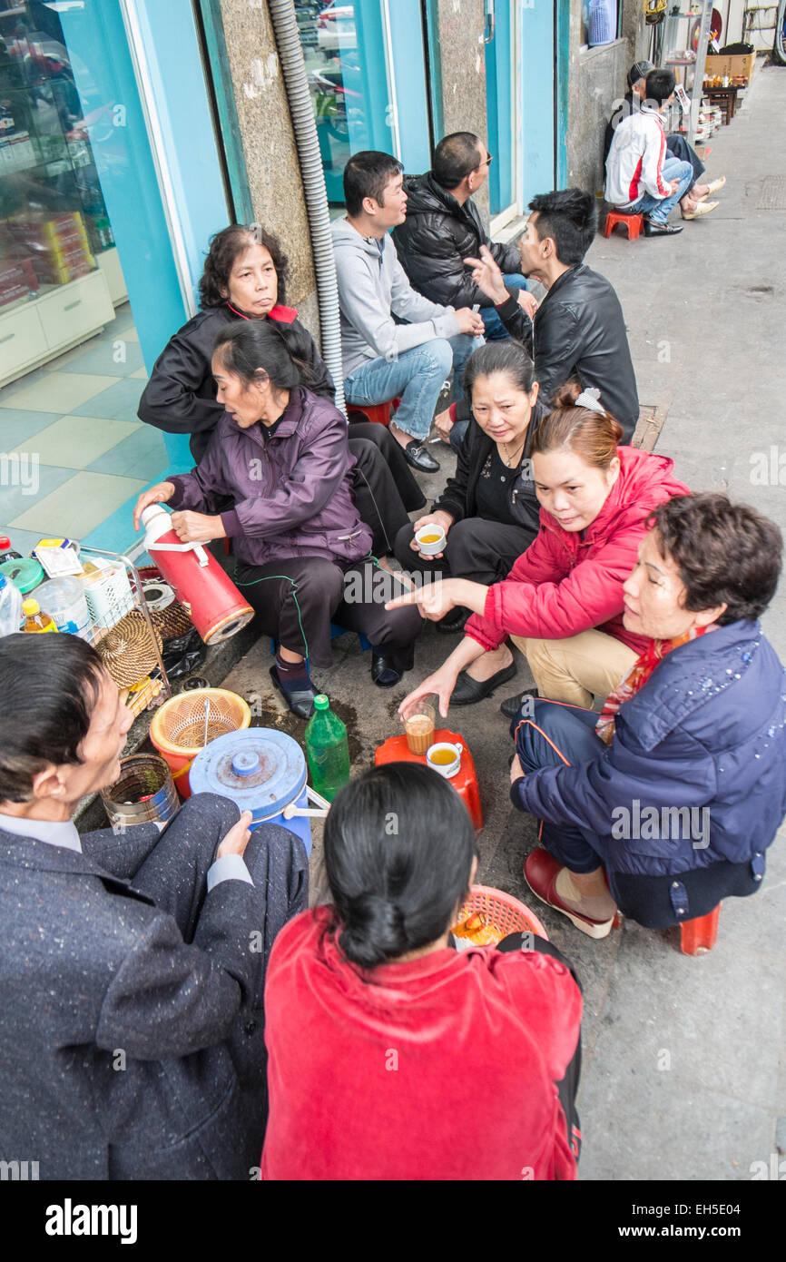 Sitting on plastic stools for a street food meal on the scooter filled ...