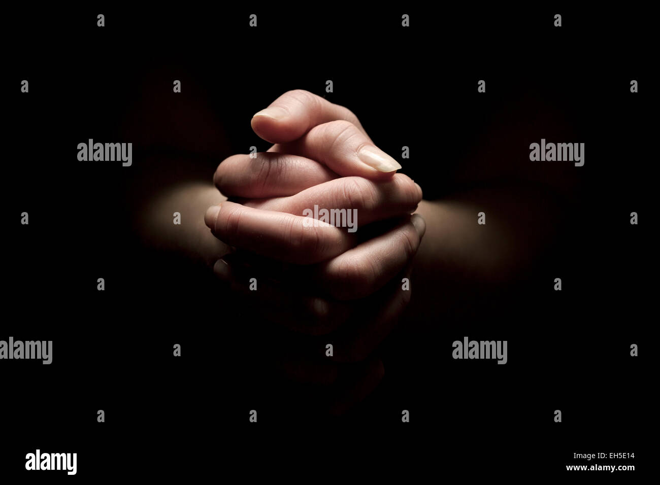 Woman praying with hands folded to God Stock Photo - Alamy