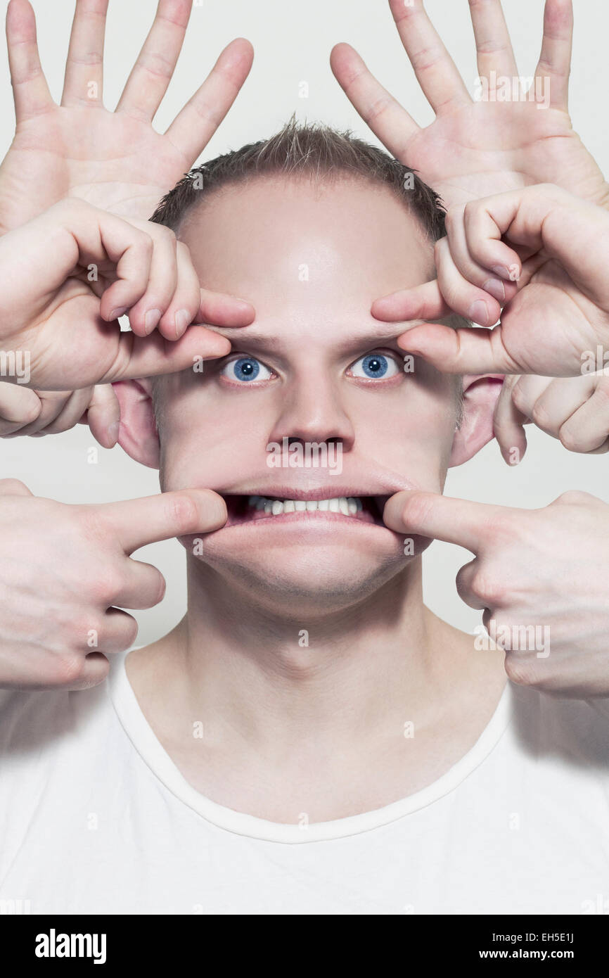 A man with hands stretching his face Stock Photo - Alamy