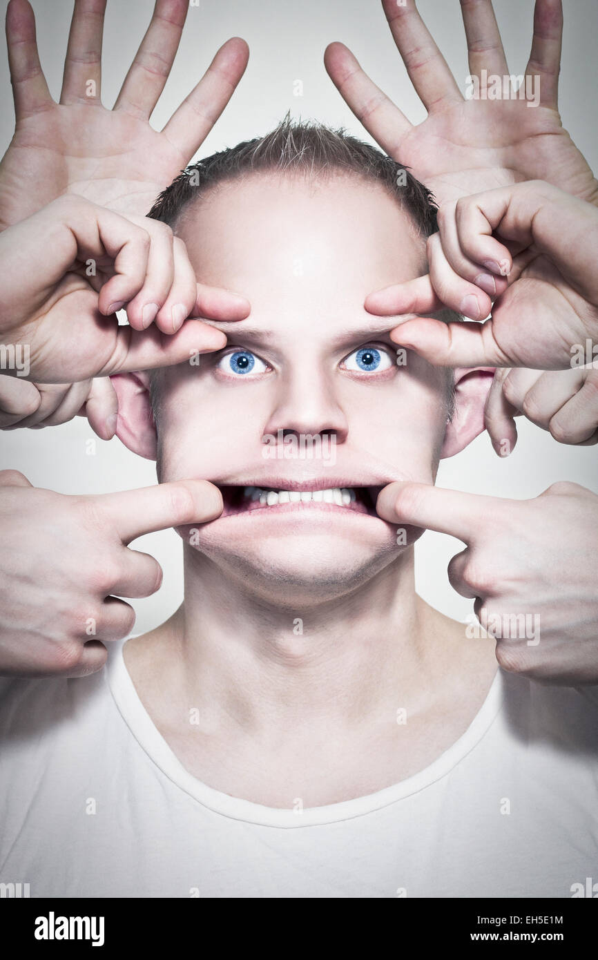 A man with hands stretching his face Stock Photo - Alamy