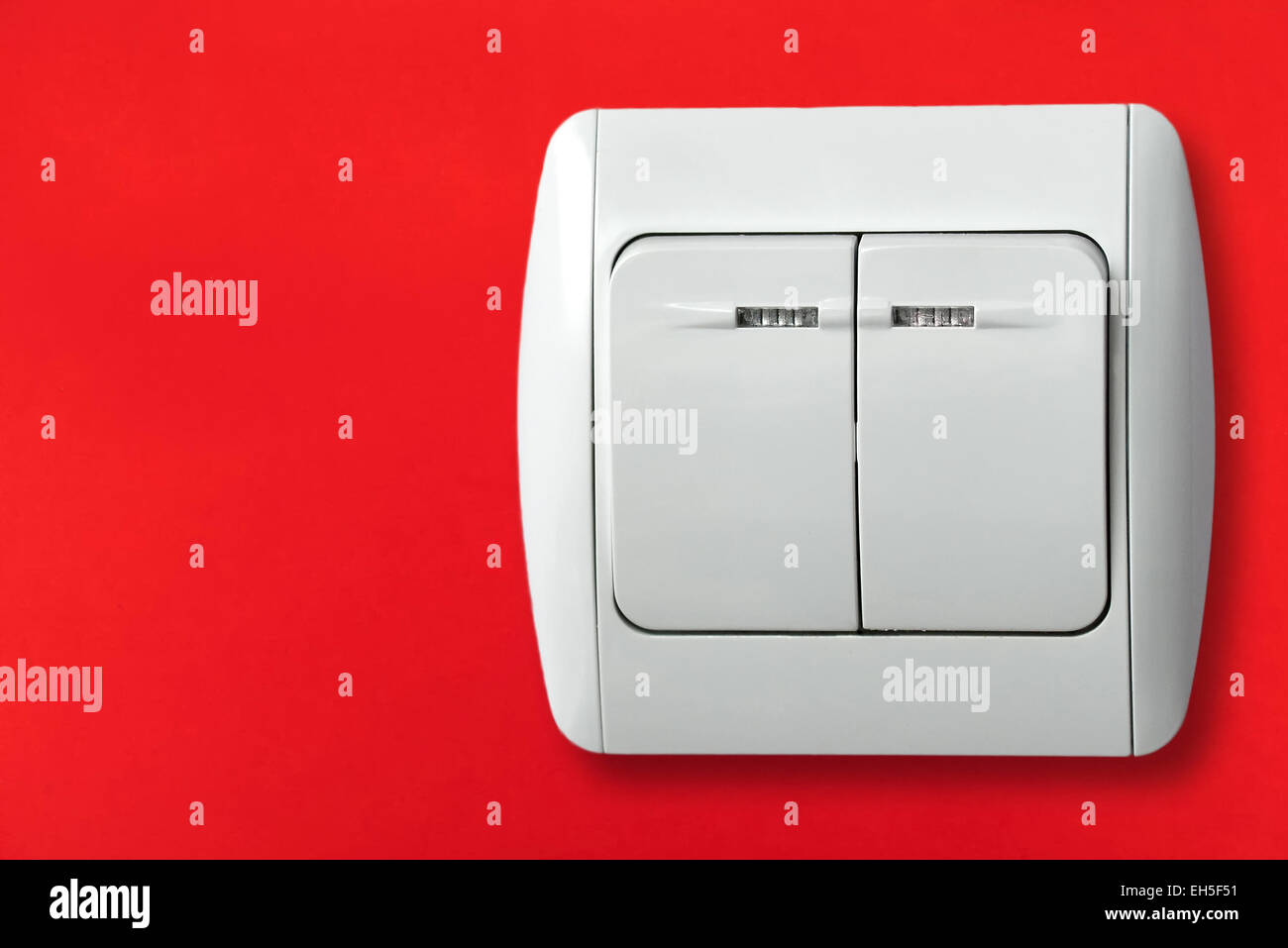 White light switch on red wall in natural light Stock Photo - Alamy