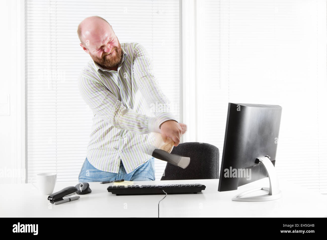 Office worker / businessman attack his computer with a axe Stock Photo ...