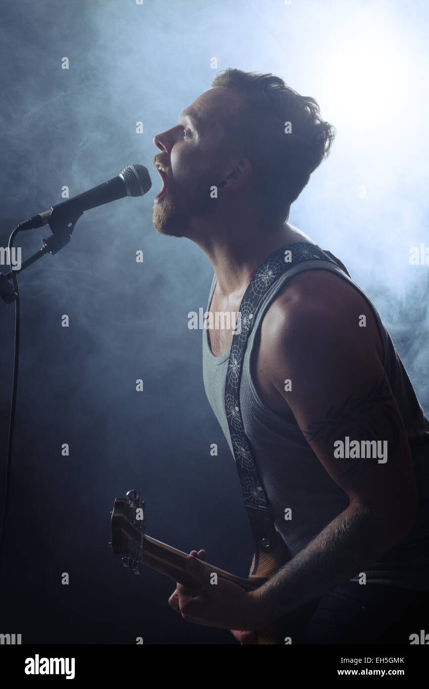 Young man playing rock concert. sings and play guitar Stock Photo - Alamy