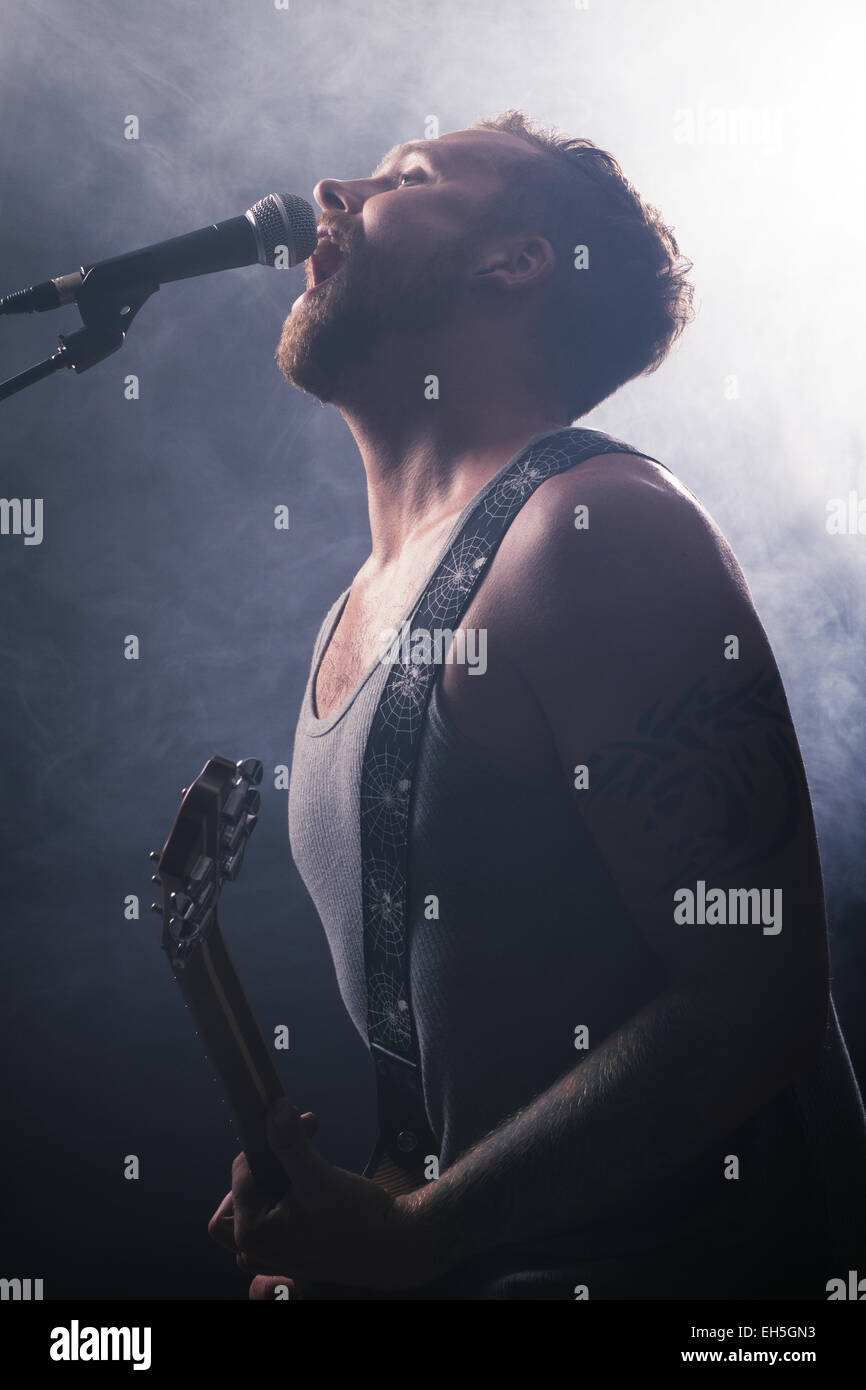 Young man playing rock concert. sings and play guitar Stock Photo - Alamy