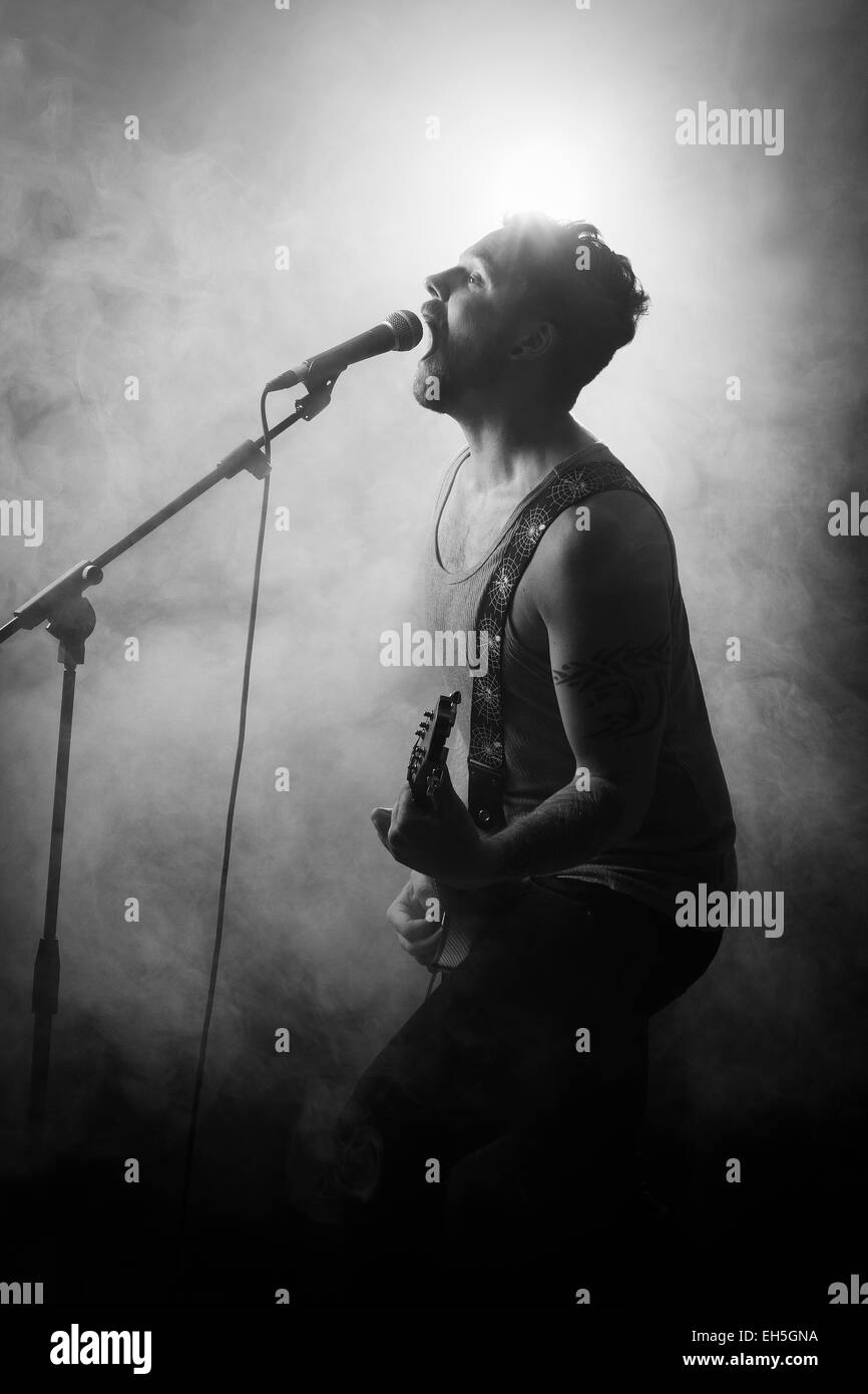 Young man playing rock concert. sings and play guitar Stock Photo - Alamy
