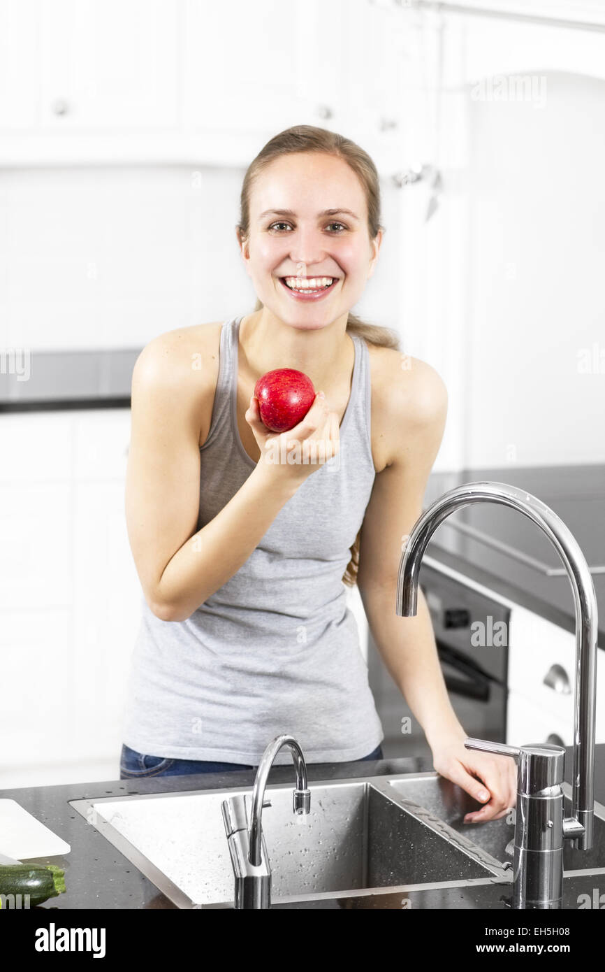 Young fit / healthy / sporty woman wash / eat an apple. Modern and ...
