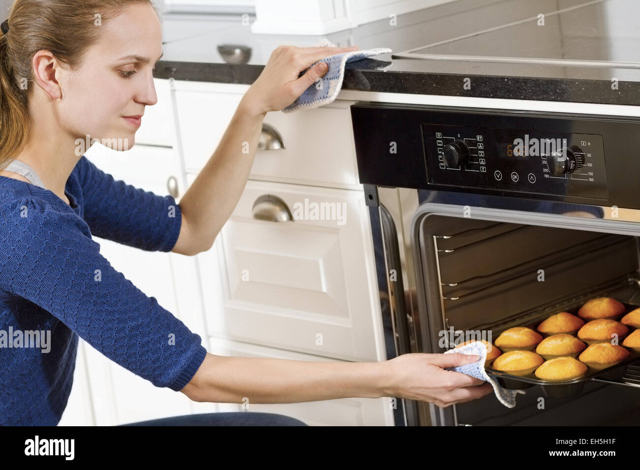 A woman making muffins in white kitchen Stock Photo - Alamy