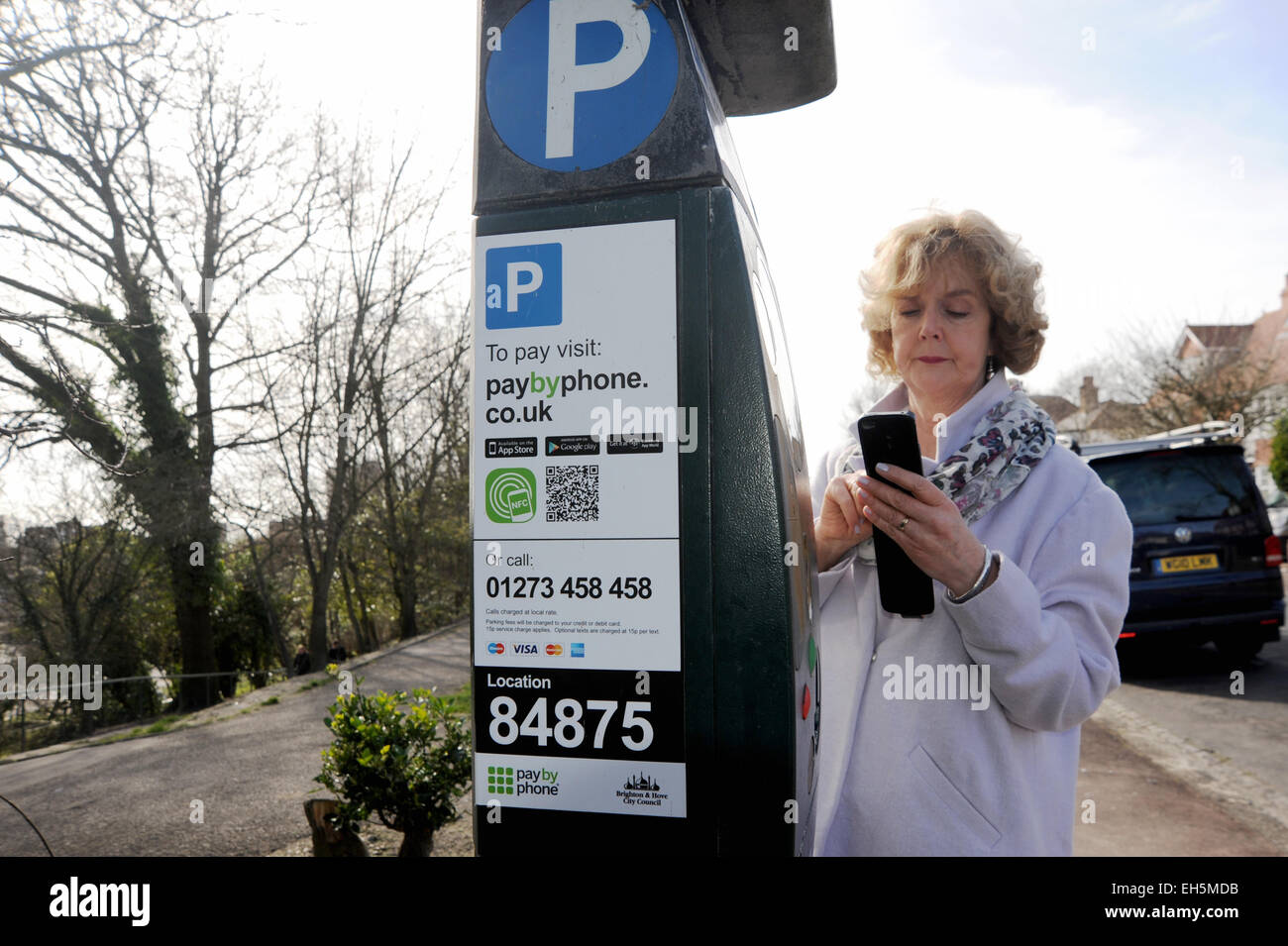 Female driver pays for parking meter using a paybyphone mobile phone ...