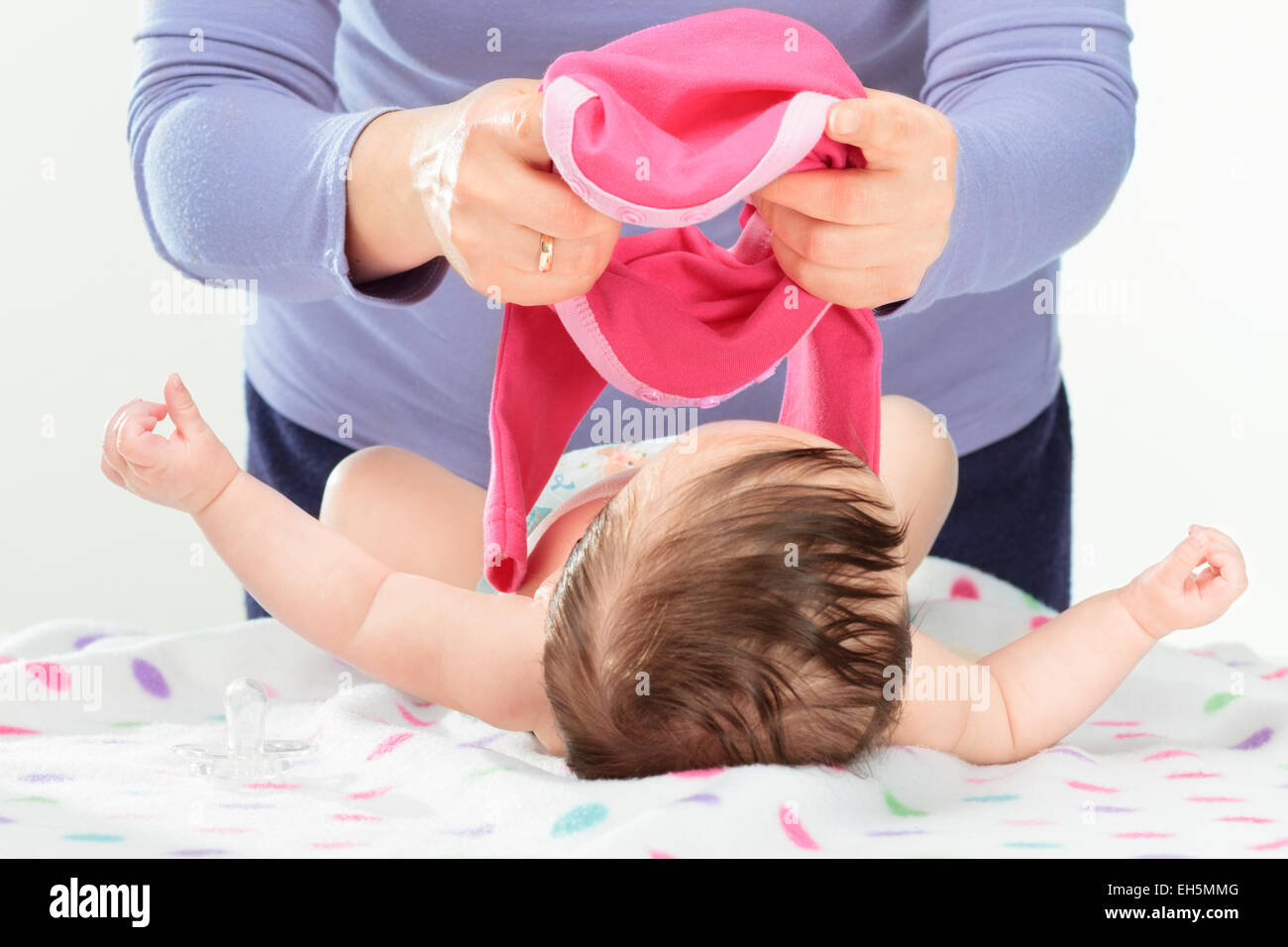 Mom dressing her little baby girl Stock Photo - Alamy