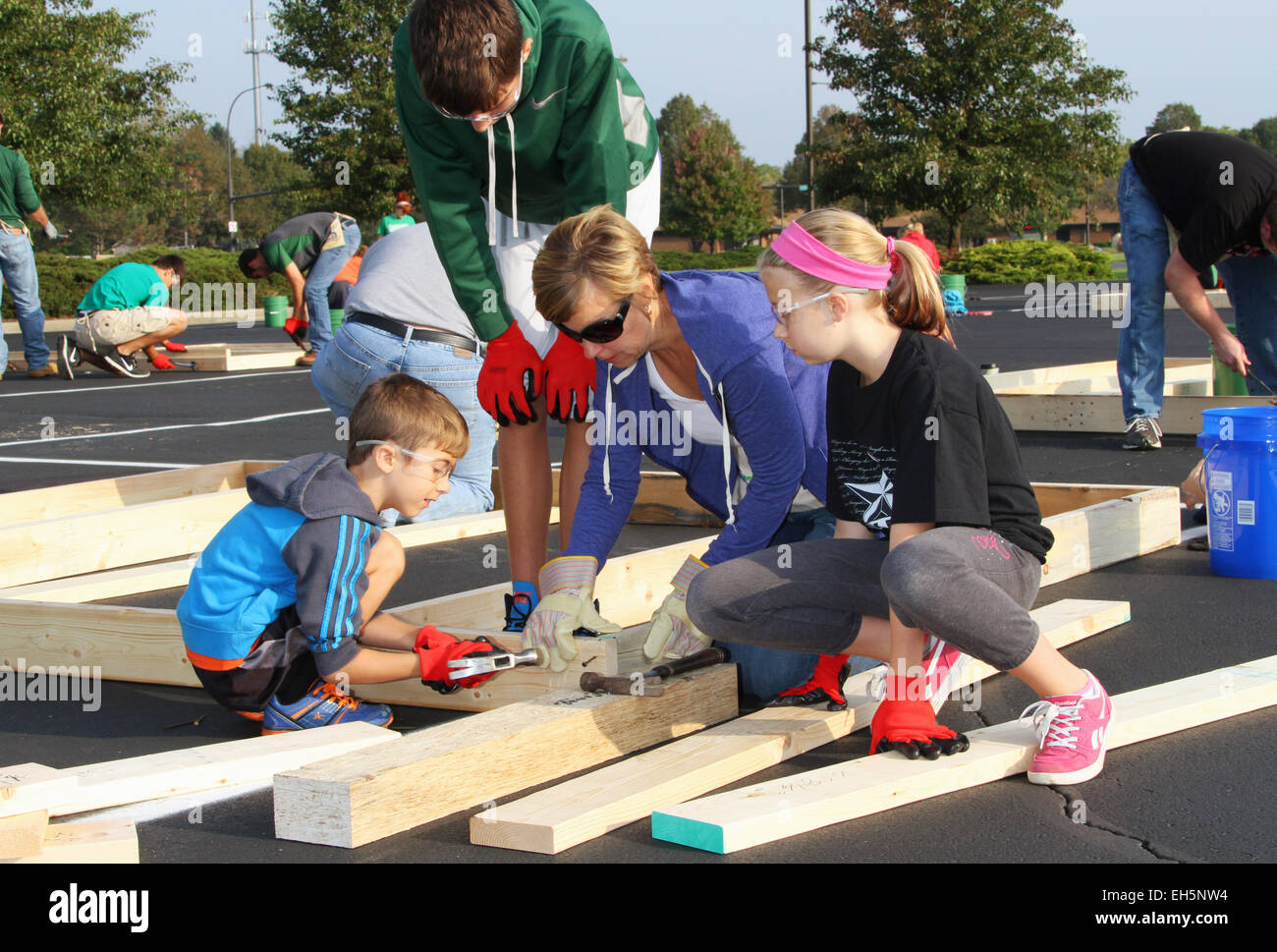 Mother and children. Volunteer people building a house wall panel ...