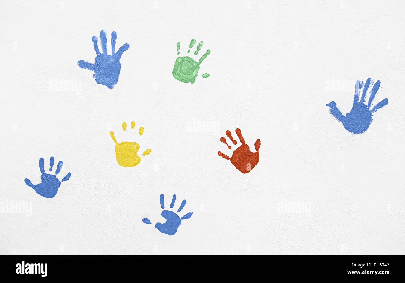 Hands of colors painted on the wall, detail of hands, textured ...