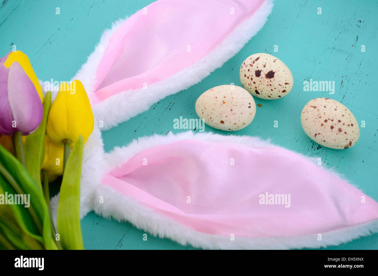 Happy Easter pink bunny ears on aqua blue wood table Stock Photo - Alamy