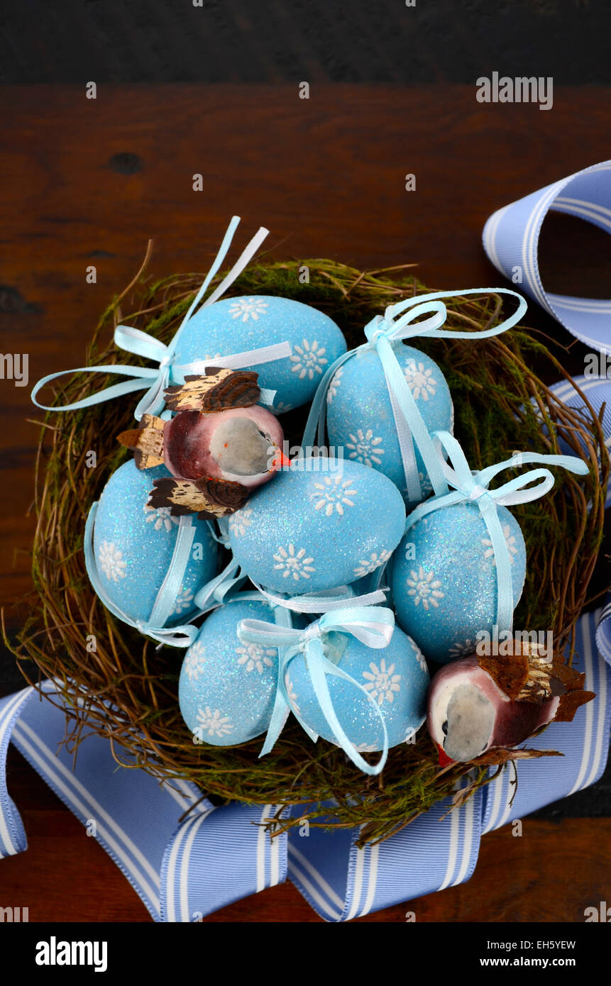 Happy Easter blue decoration eggs in birds nest on dark wood table ...