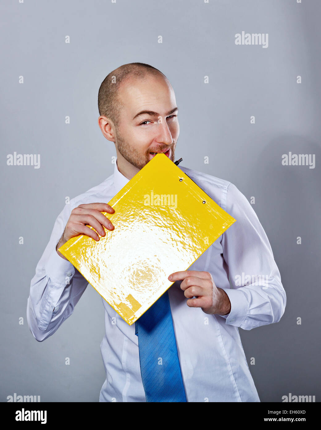 Businessman in shirt and tie biting folder with papers. Business people ...