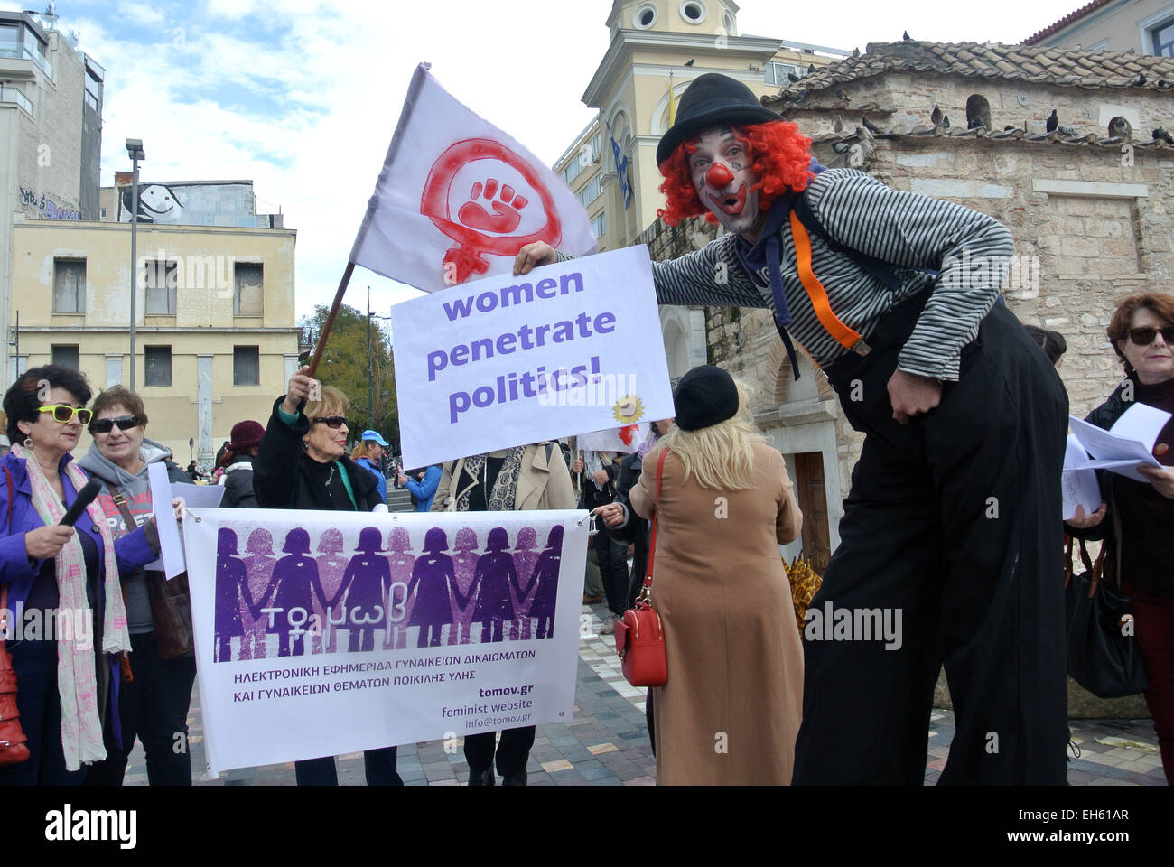 A man on stilts joins the demonstration carrying a picket. People in ...