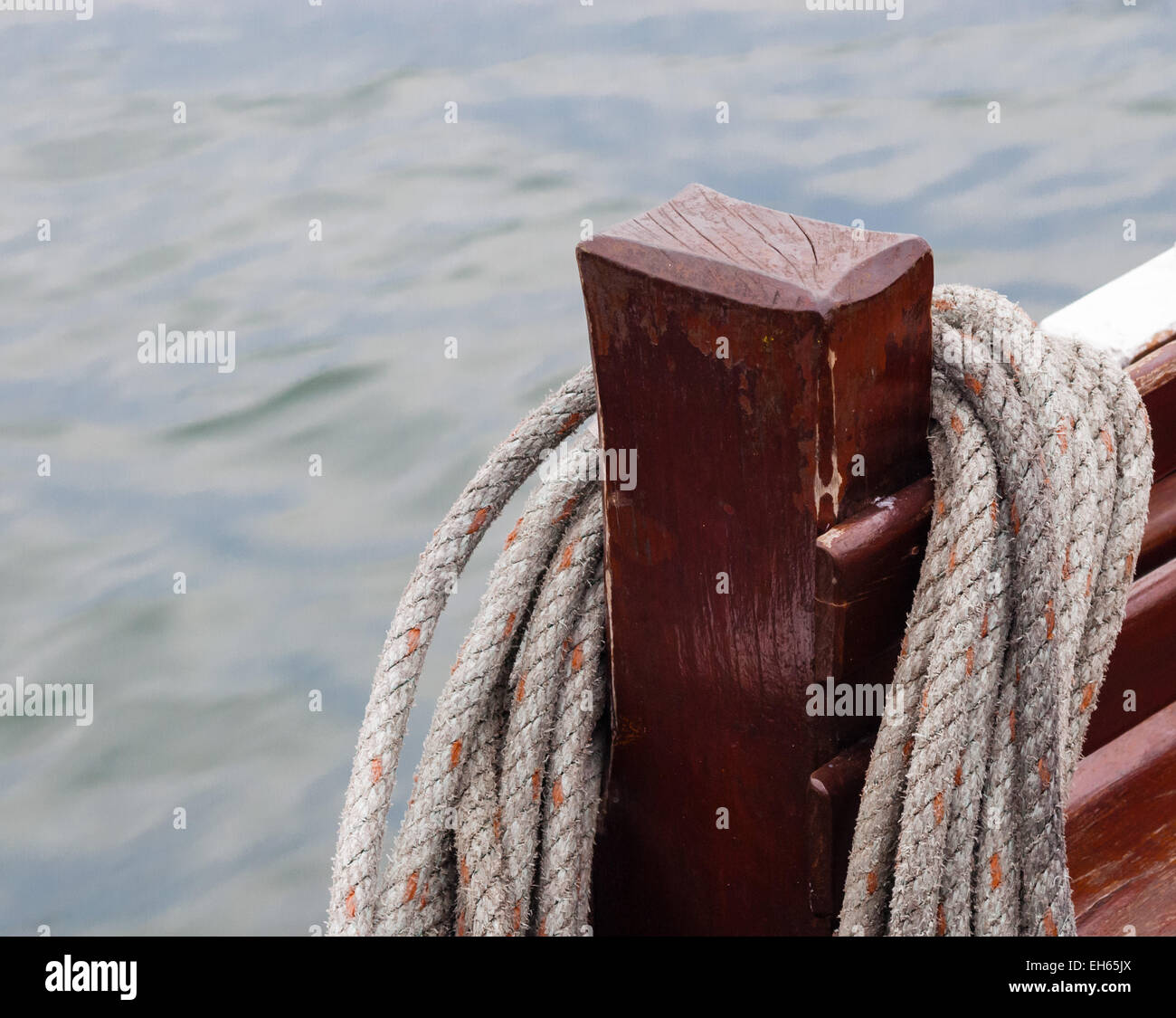 Coiled rope hung on wooden post on boat Stock Photo - Alamy