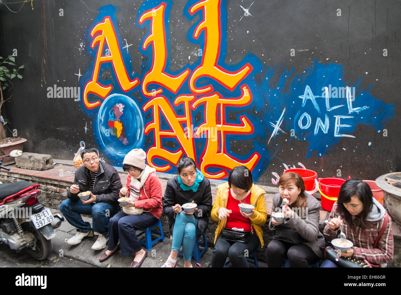 Eating food while sitting on small stools at street food stall with ...