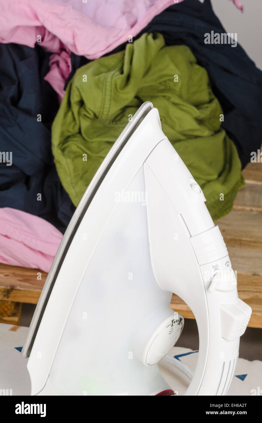 Iron and a big heap of messy, crumpled clothes Stock Photo - Alamy