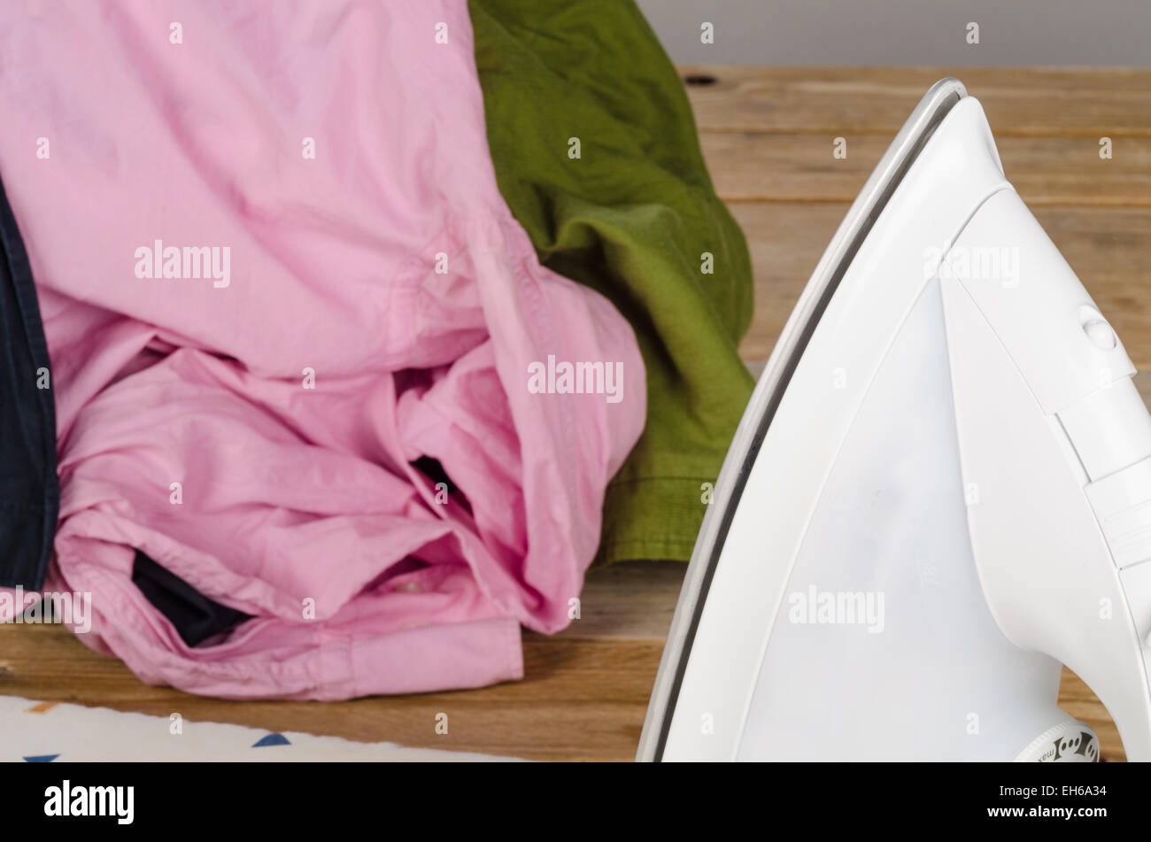 Iron and a big heap of messy, crumpled clothes Stock Photo - Alamy