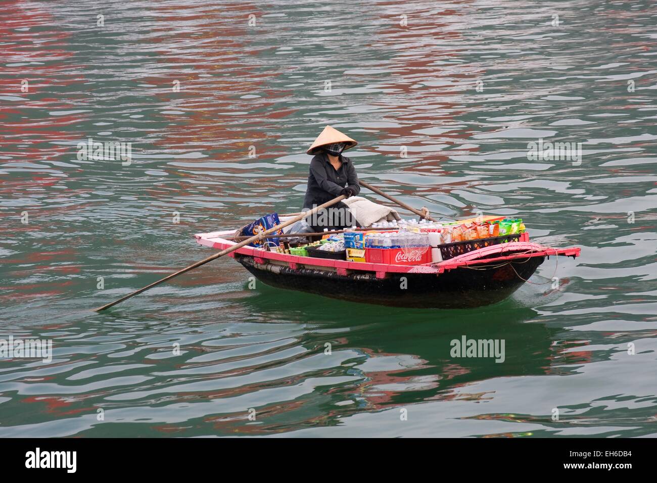 Floating market, vendor in boat with food, Halong Bay Stock Photo - Alamy