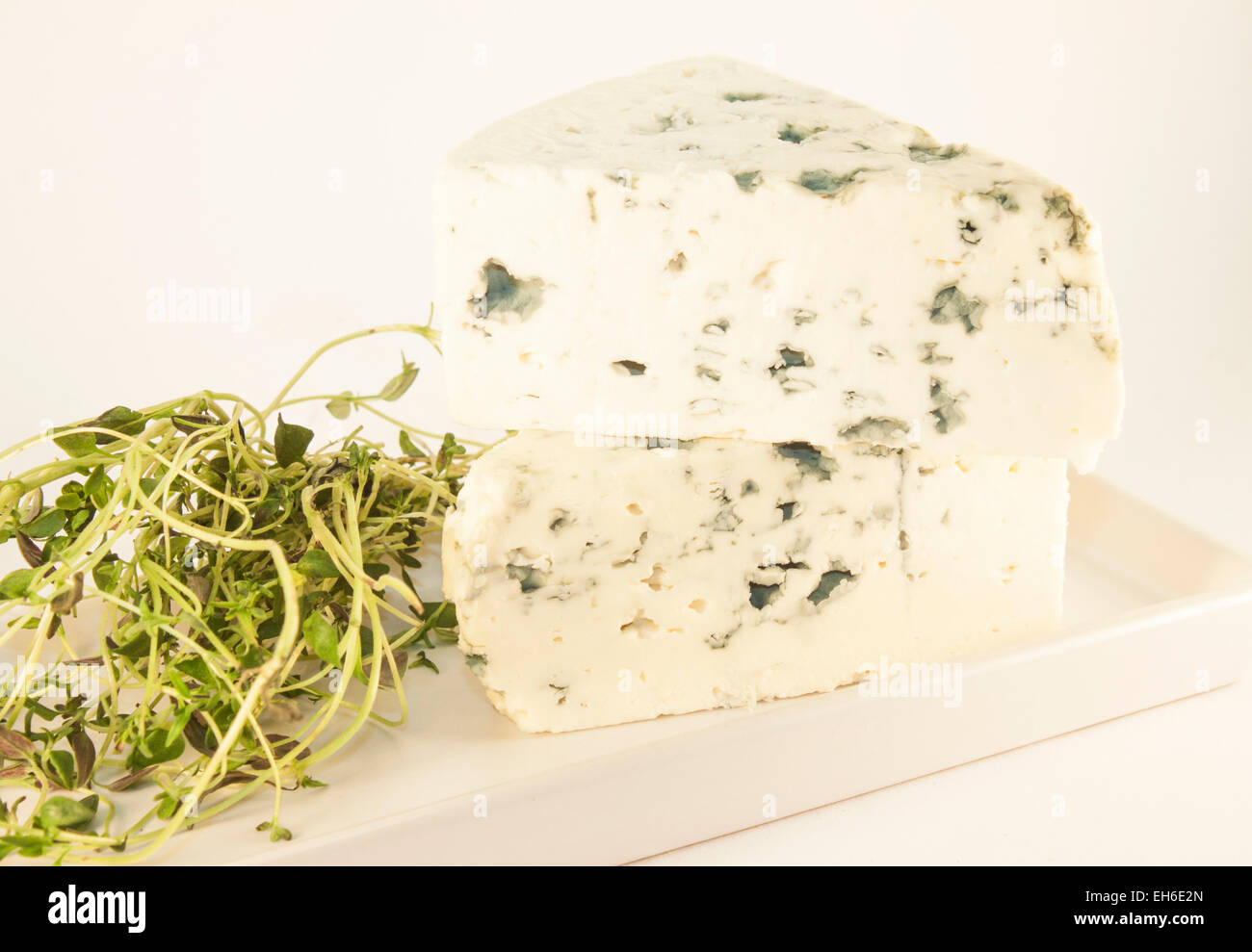 Two triangles of blue cheese and thyme, isolated on white background ...