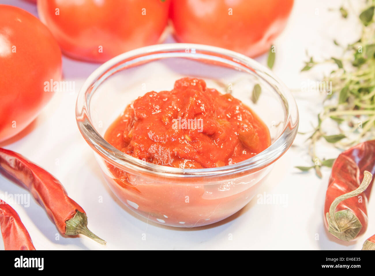 A glass full of colorful salsa sauce, on a white table Stock Photo - Alamy