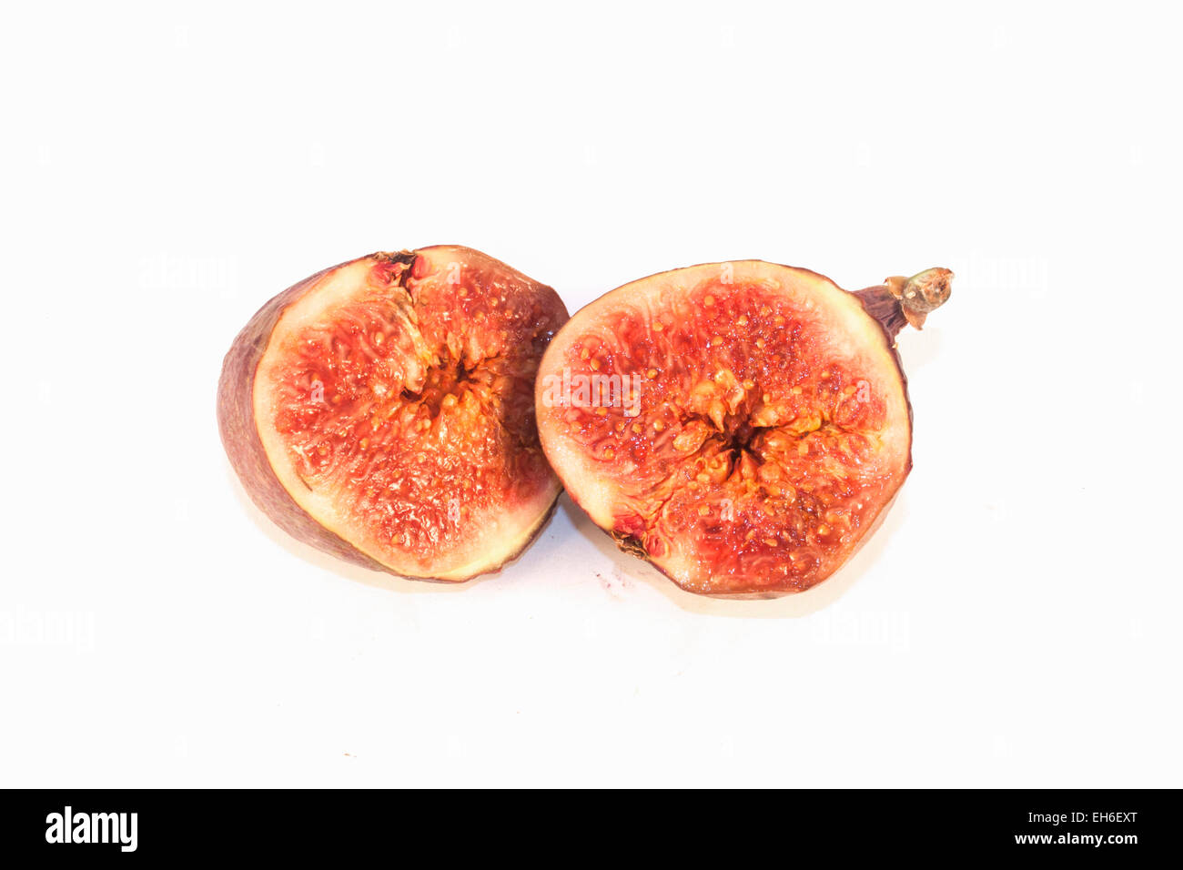 Two halves of purple figs, isolated on white background Stock Photo - Alamy