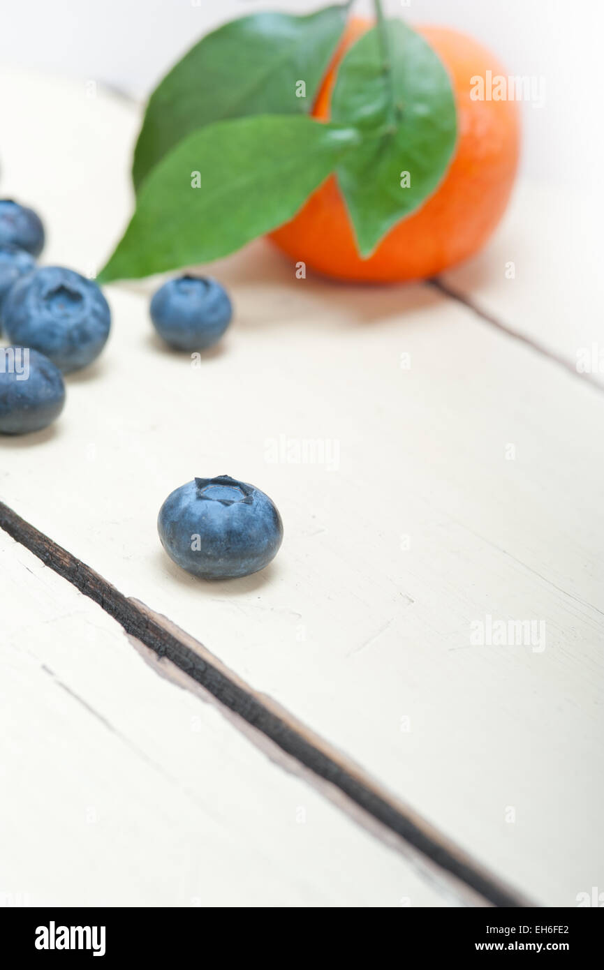 tangerine and blueberry on white rustic wood table Stock Photo - Alamy