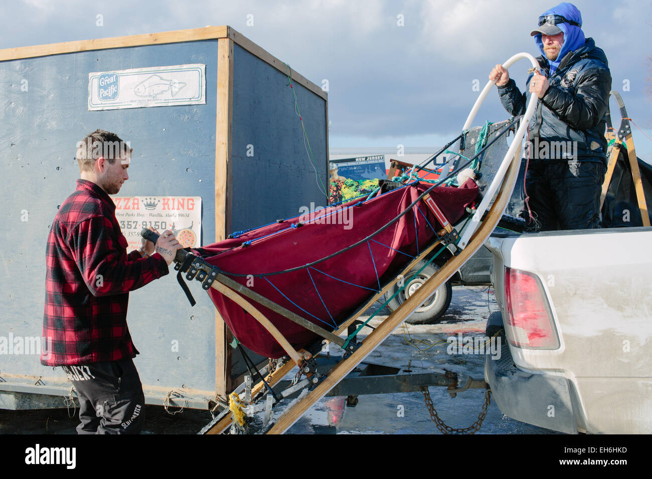 Jason Mackey (right) loads a dog sled in the back of a truck following ...